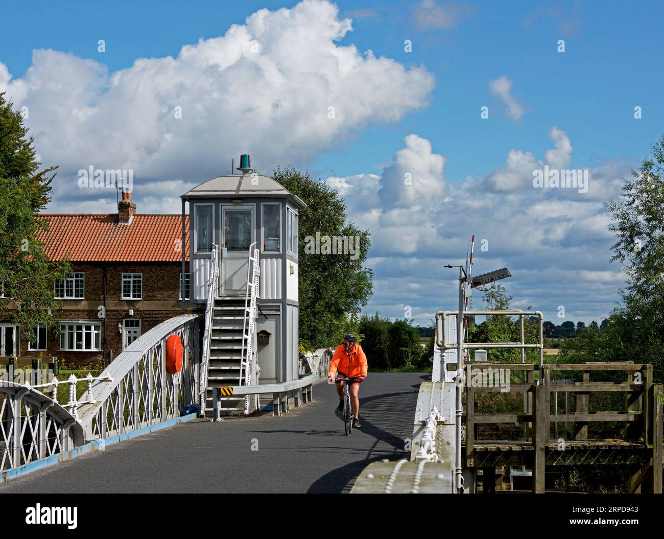 Male cyclkist crossing the swing bridge across the river Ouse at Cawood ...