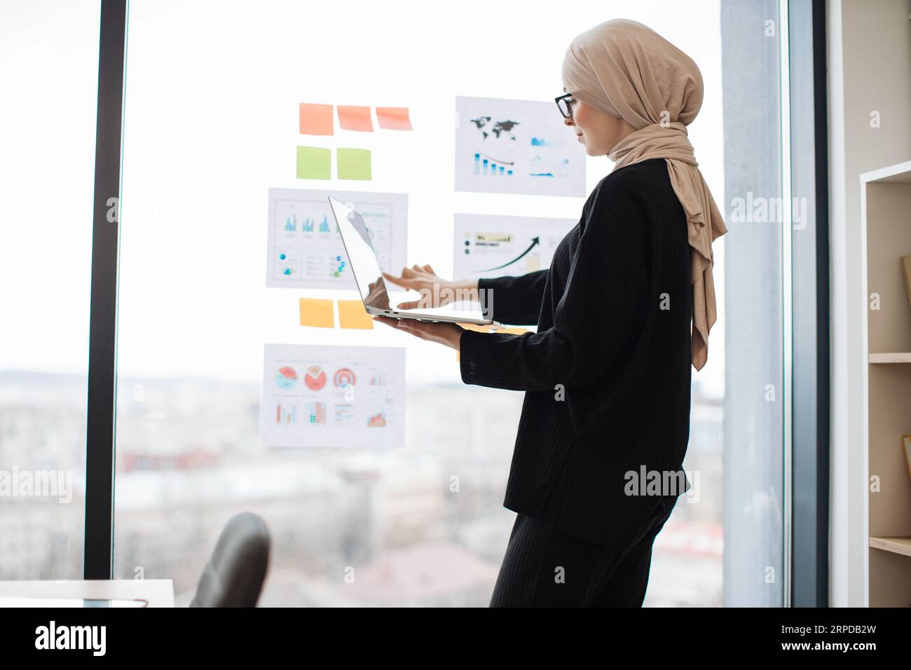 Muslim employee using charts in office work via computer Stock Photo ...