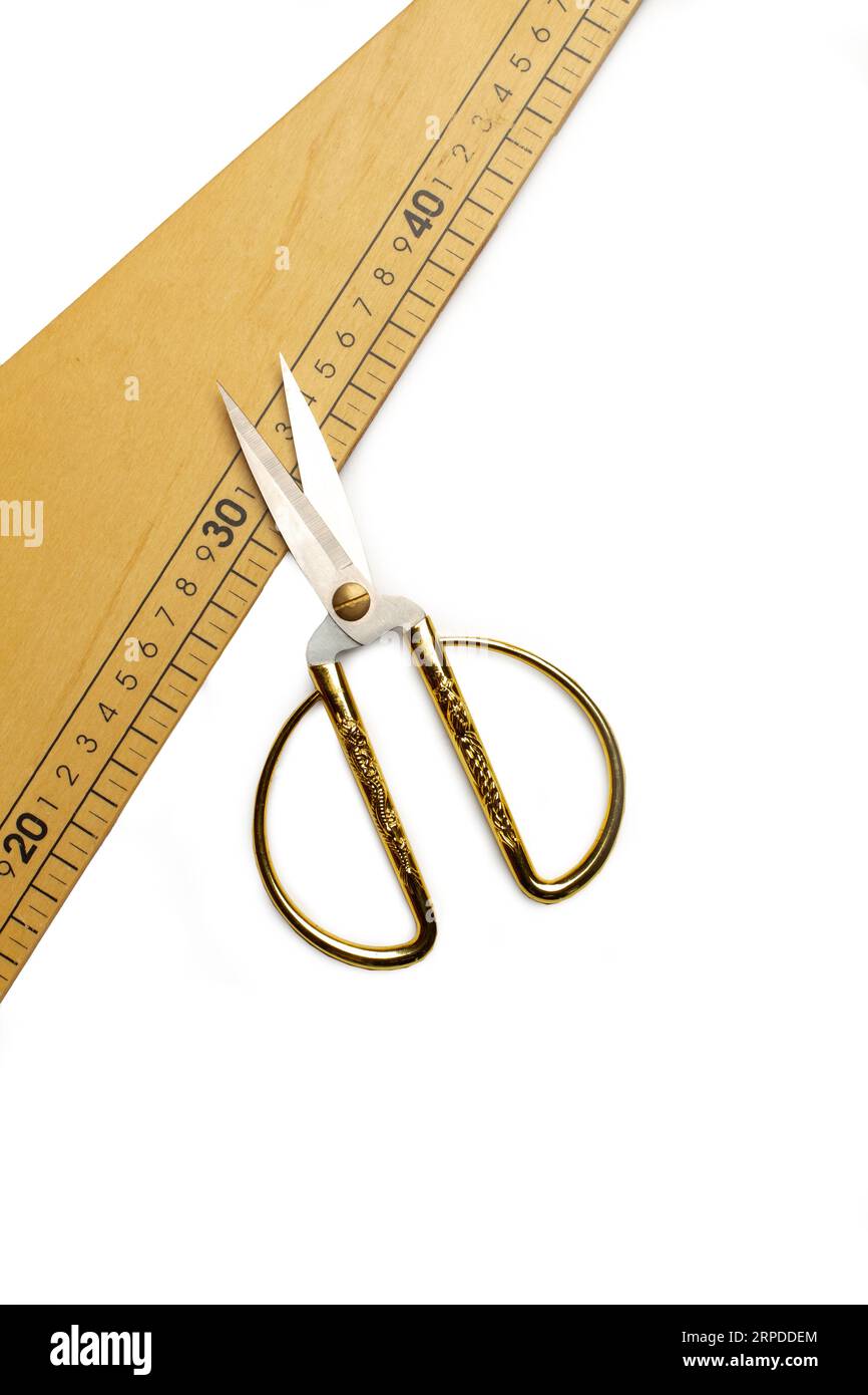 Wooden triangle ruler and scissors on a white background with copy ...