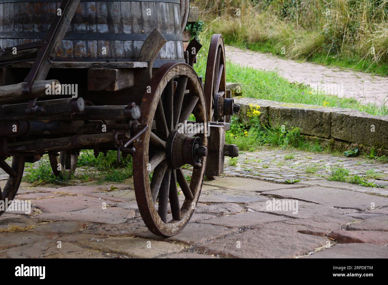 A rustic wooden cart in a rural environment, its wooden wheels ...