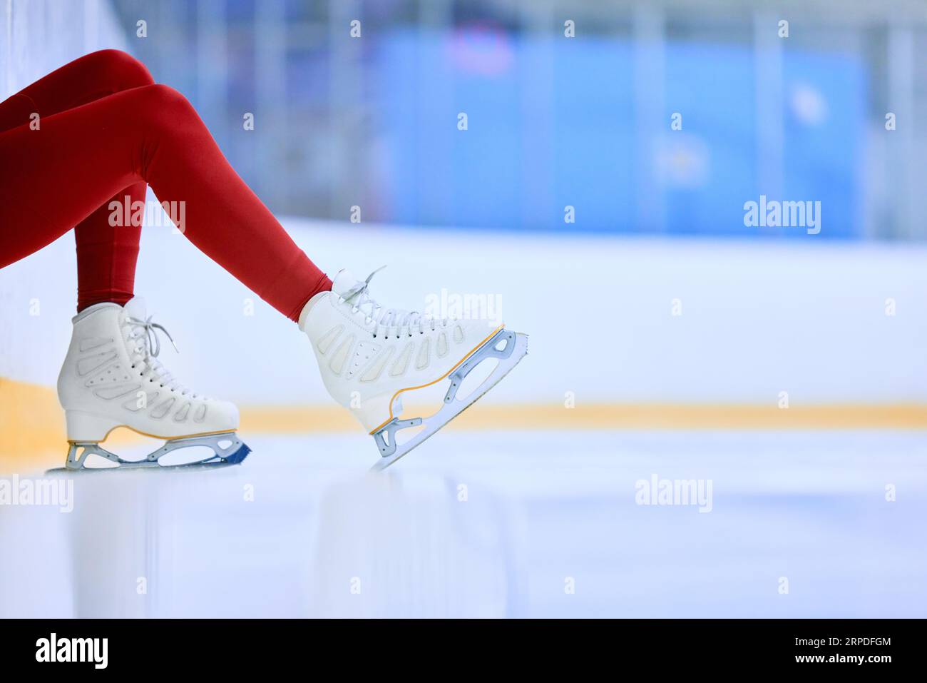 Close-up cropped image of female legs in red leggings and white skates ...