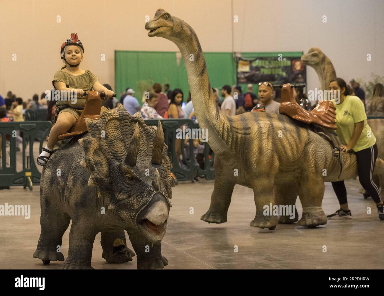 (190805) -- HOUSTON, Aug. 5, 2019 (Xinhua) -- A girl rides a dinosaur ...