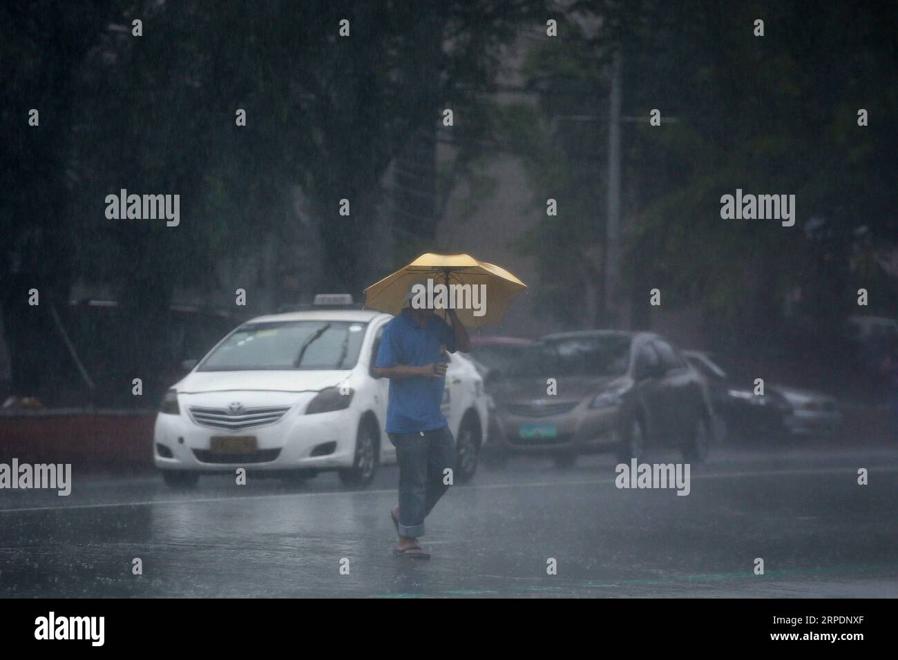 (190809) -- QUEZON CITY, Aug. 9, 2019 -- A man walks in the strong ...