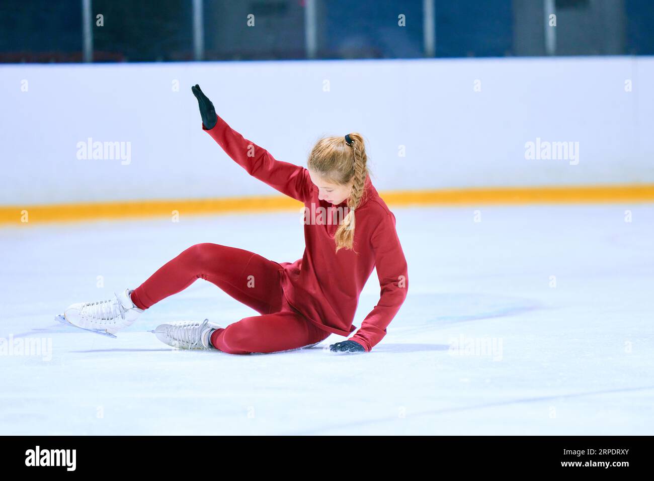 Challenges. Girl, figure skating athlete in red sportswear falling down ...