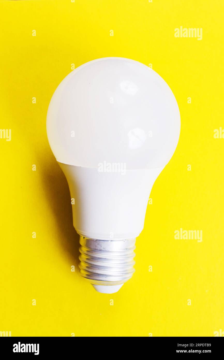 Light bulb on bright yellow background close up Stock Photo - Alamy