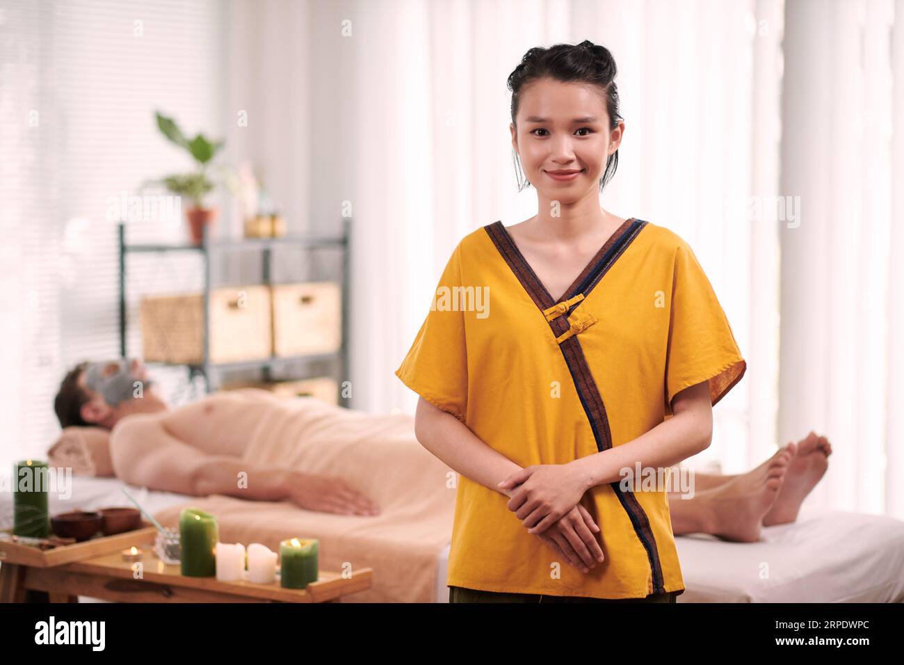 Pretty Asian girl in yellow uniform standing in front of camera against ...