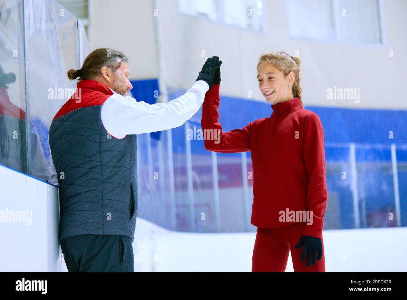 Success. Figure skating trainer, coach cheering his student, girl ...