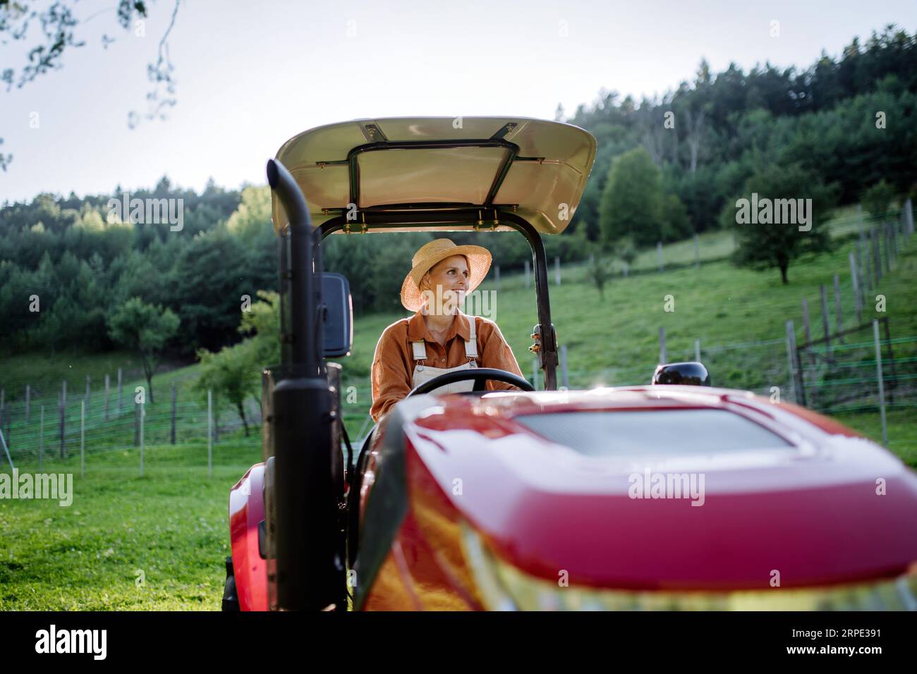 Progressive female farmer driving tractor on her own farm Stock Photo ...