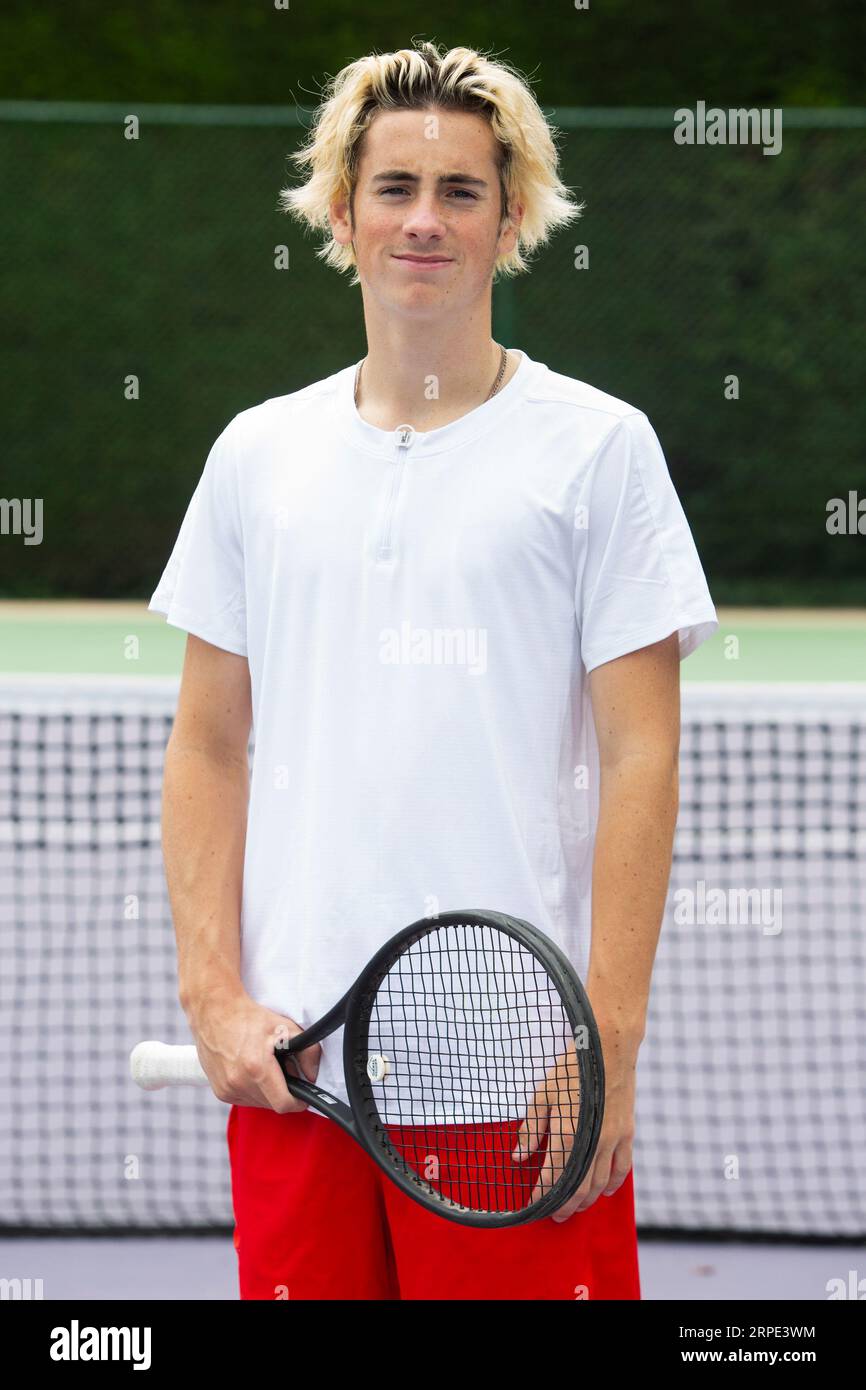 Young, determined Caucasian tennis player poses for the camera in a ...