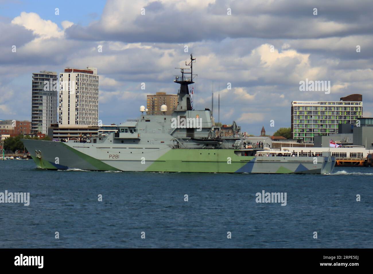 Passing coastal apartment blocks as she sails towards her harbour berth ...