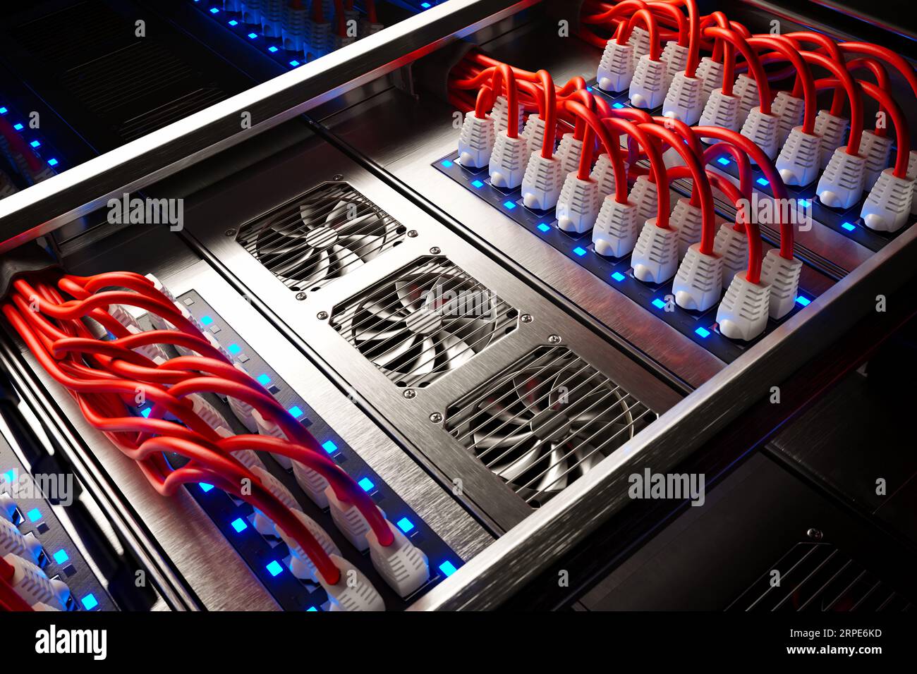 Many red cables and spinning fans in a server cabinet lit by a ...