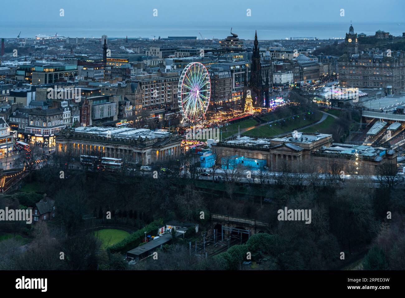 This image captures the cityscape during dusk, illuminated by an array ...