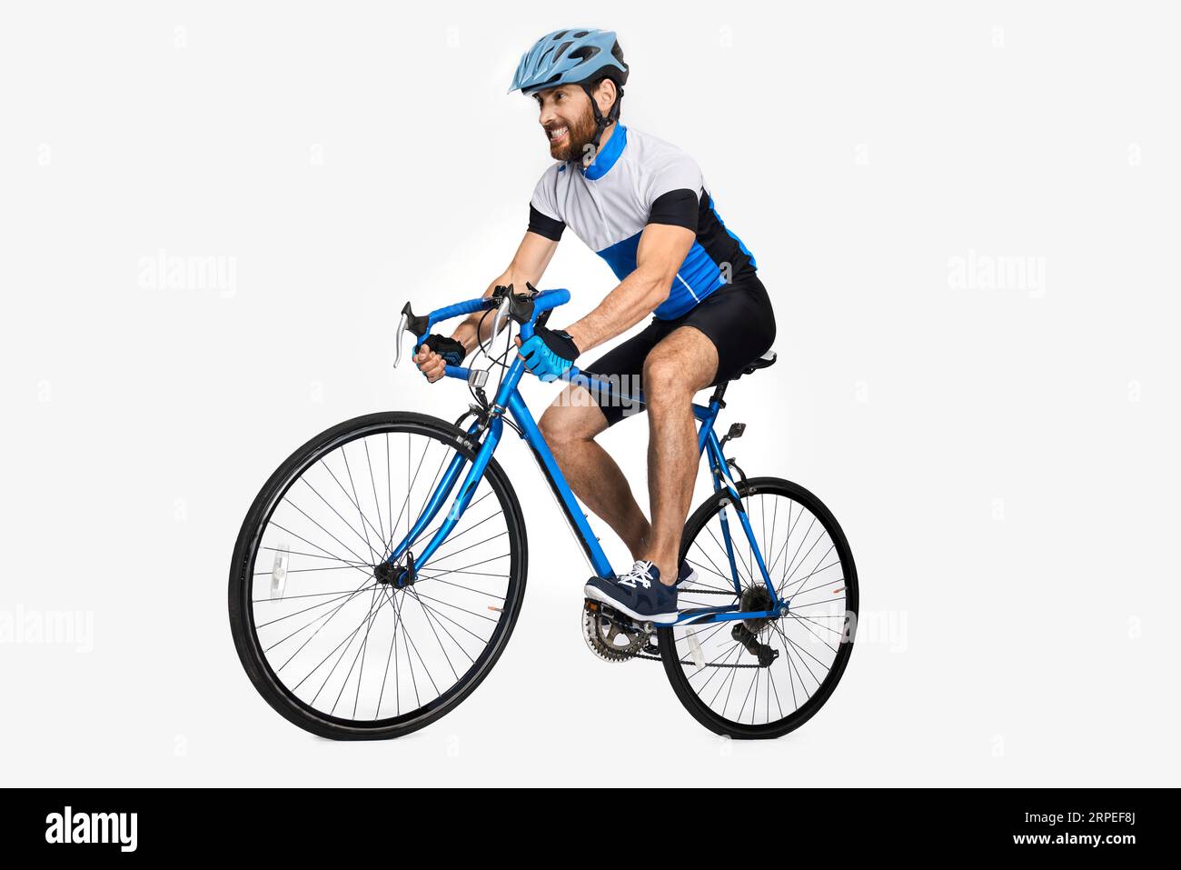 Bearded caucasian cyclist wearing sports equipment, riding bike. Side ...