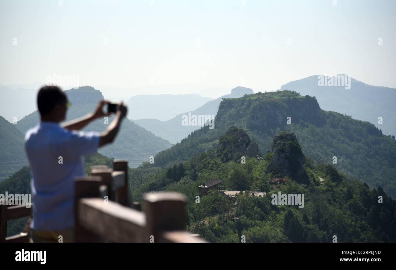 (190830) -- MENGYIN, Aug. 30, 2019 -- A tourist takes photos at Daigu ...