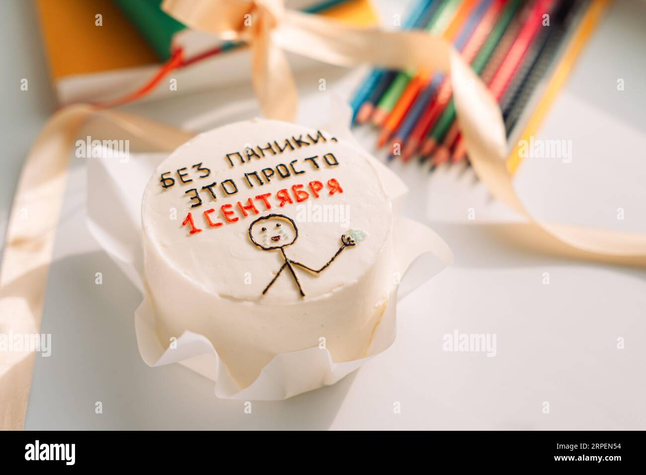 The inscription on white round cake in gift container with ribbon on ...