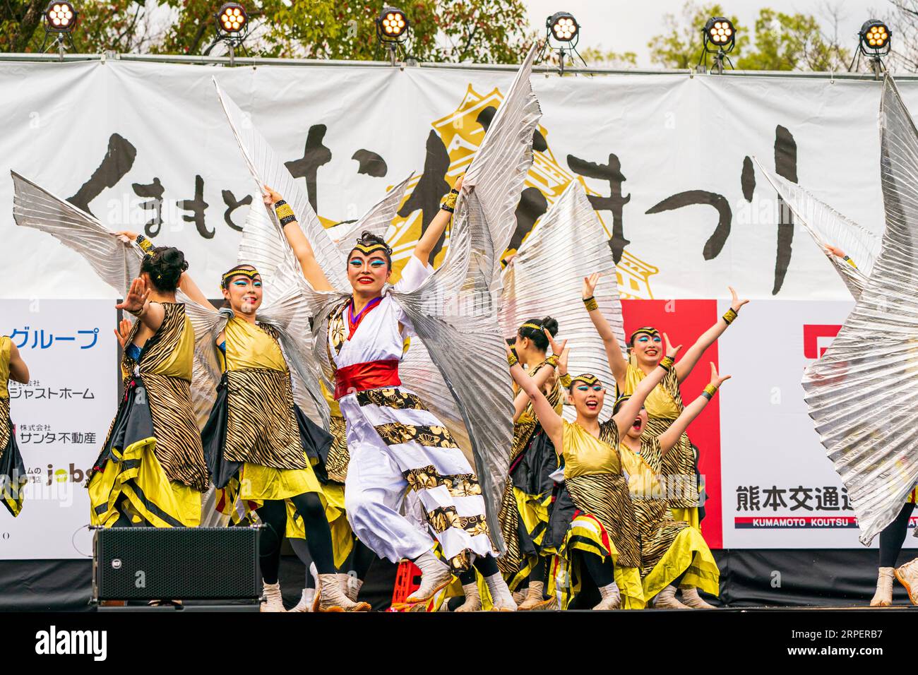 Japanese teenage women Yosakoi dance team in yellow and black costumes ...