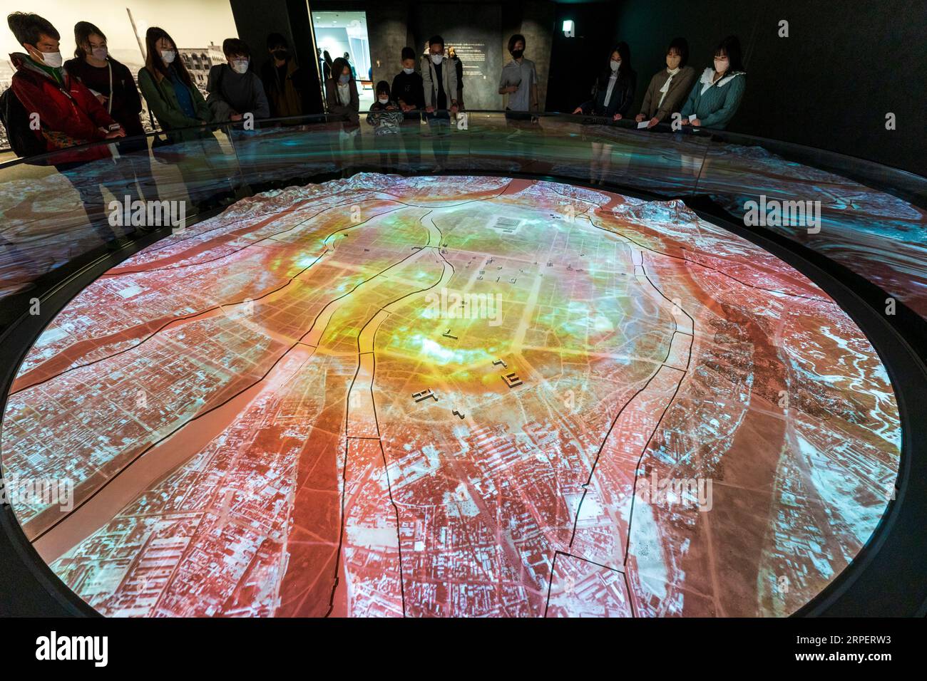 Interior of Hiroshima Peace Museum. People in darkened area viewing a ...