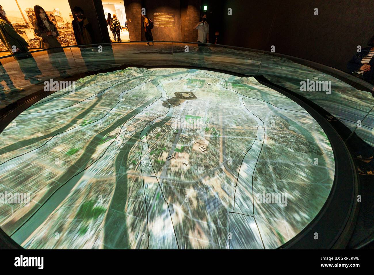 Interior of Hiroshima Peace Museum. People in darkened area viewing a ...