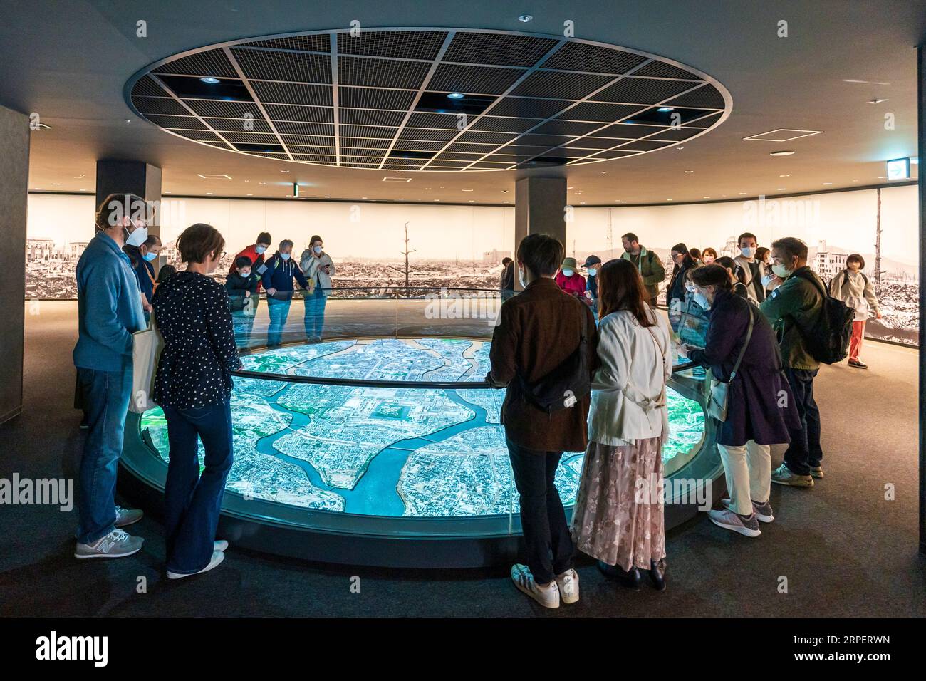Interior of Hiroshima Peace Museum. People in darkened area viewing a ...