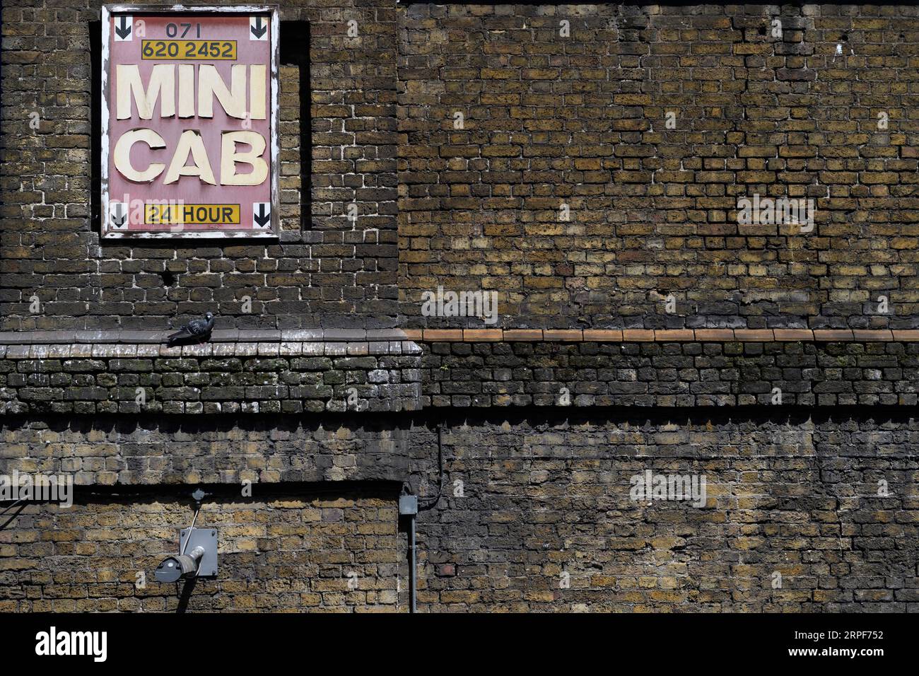 An old Mini Cab sign fixed to a railway bridge, Waterloo, London, UK ...