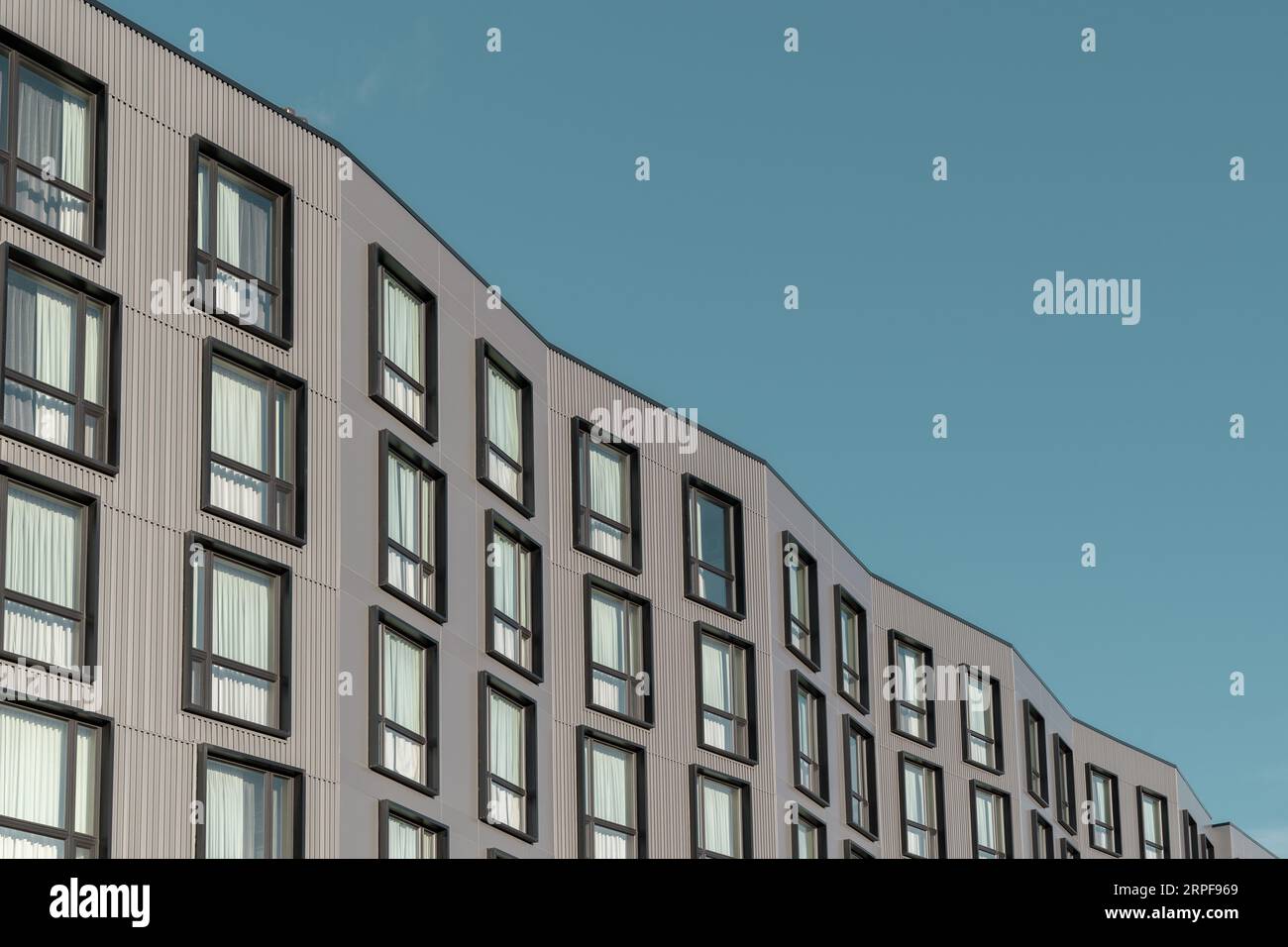 Side view of a hotel building with many windows and metal facade in a ...