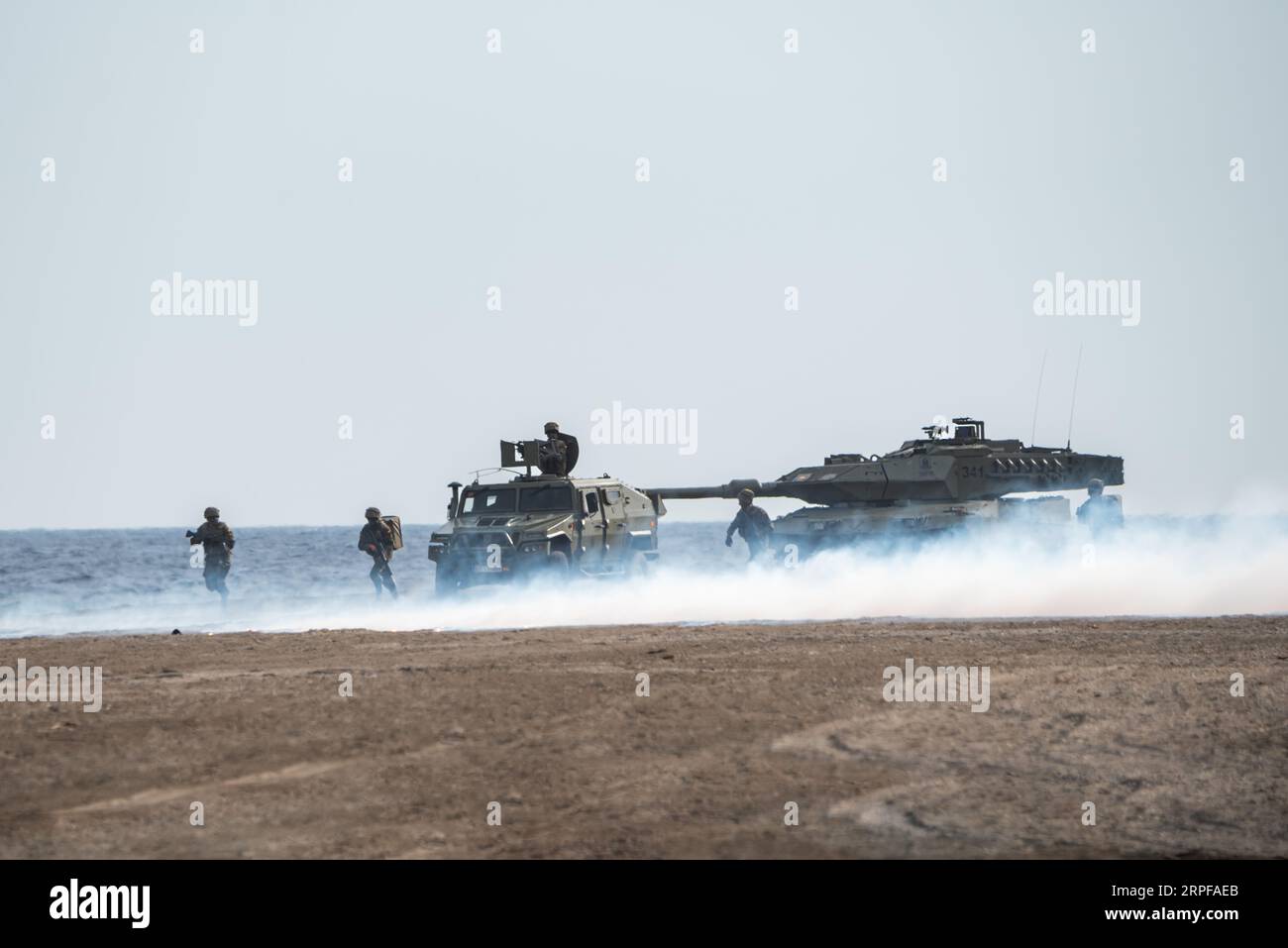 Battle tank, assault vehicle and soldiers under a smoke screen at the ...