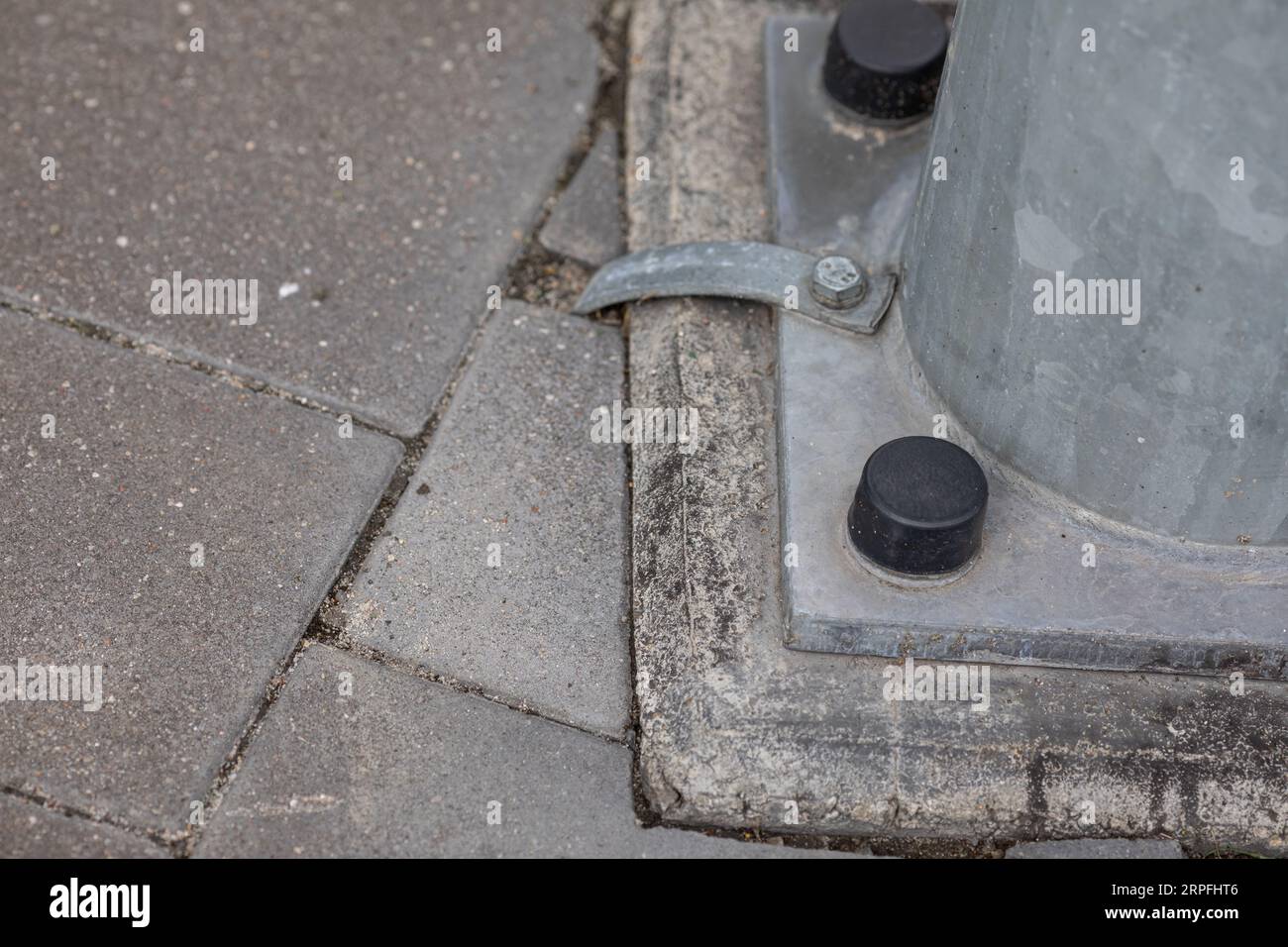 A metal lamp post attached to a concrete base Stock Photo - Alamy