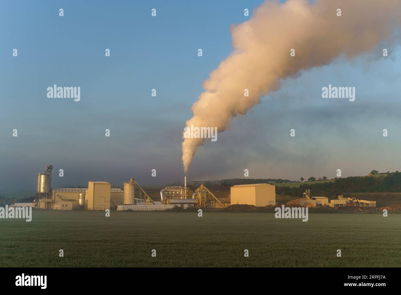 View of a high chimney with smoke ejection. Factory pipes pollute the ...