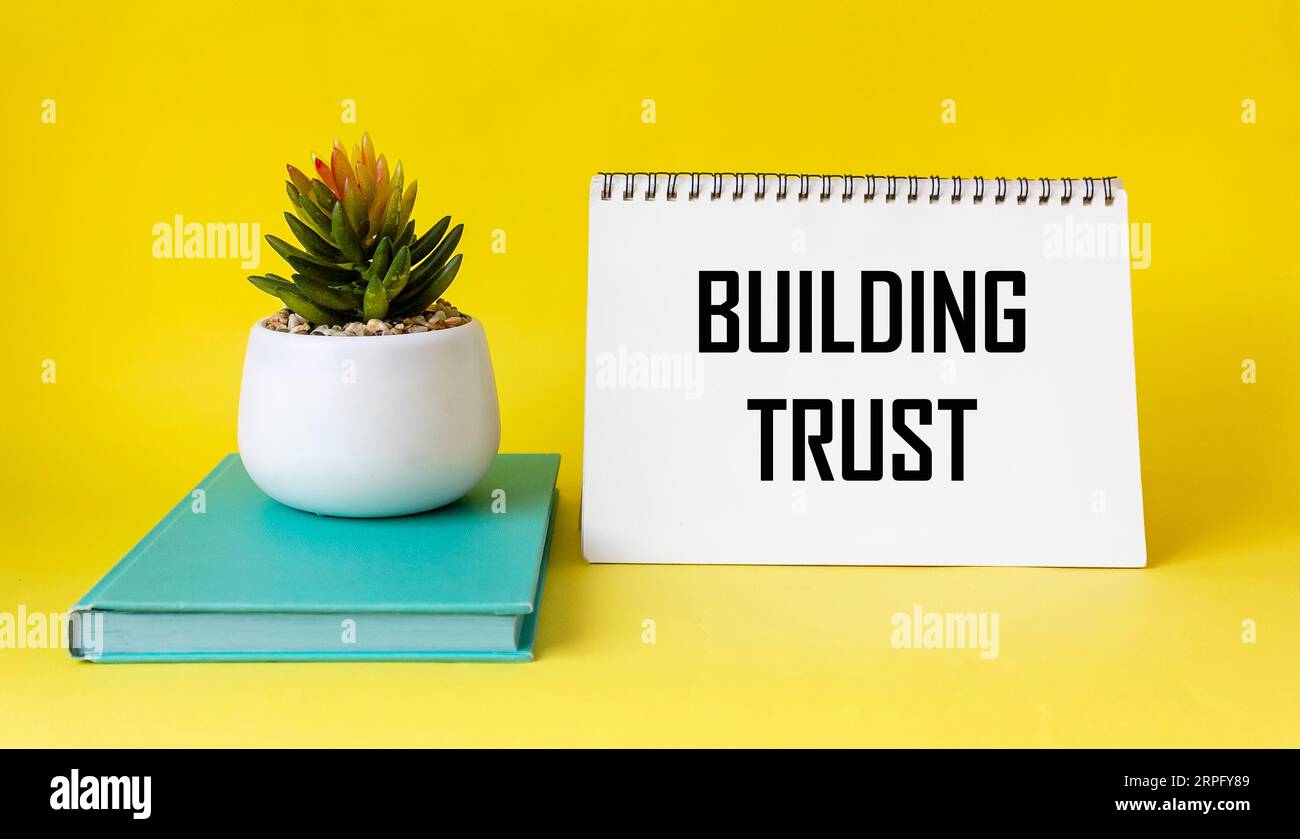 Confidence building text on notepad and yellow background with flower ...