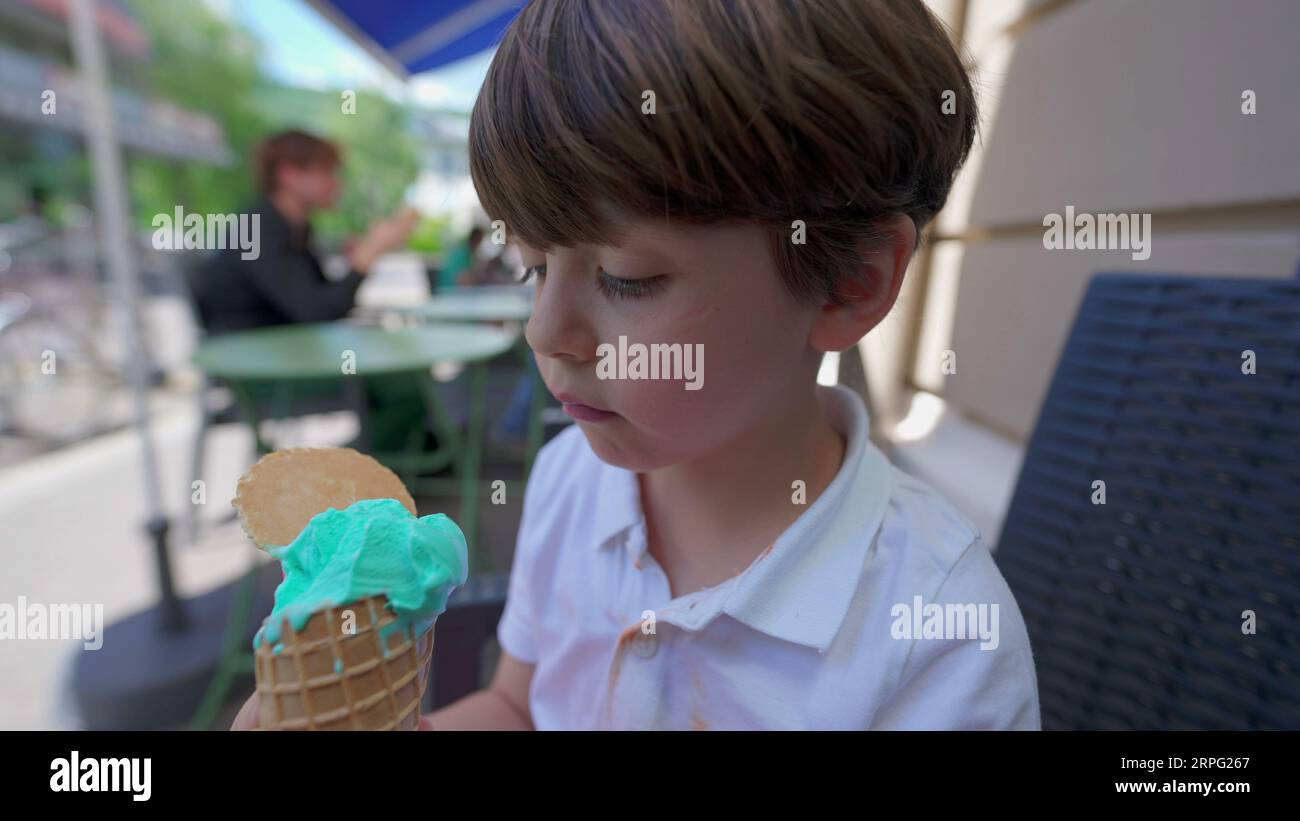 Little Boy Savors Ice-Cream cone on a Summer Day. Child licking ...