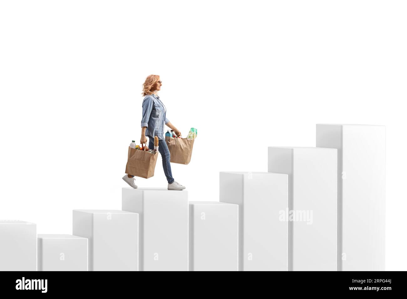 Full length profile shot of a woman carrying grocery bags and walking ...