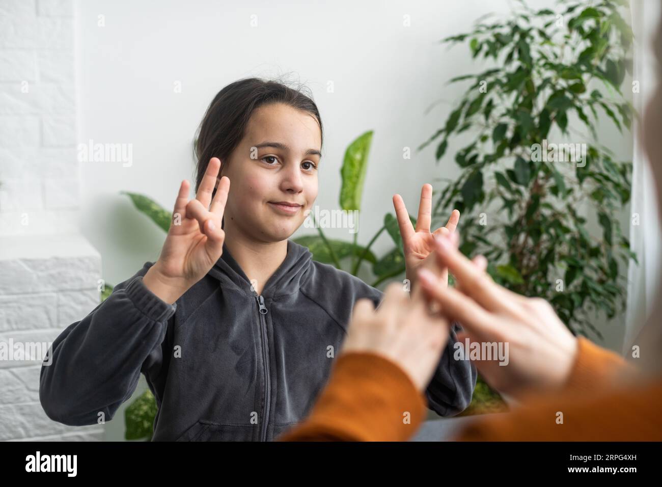 Cute little girl make hand gesture learning sign language with mom or ...
