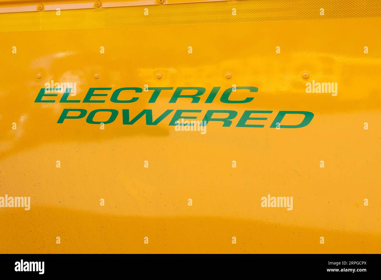 Side of a parked yellow electric school bus at a charging station Stock ...