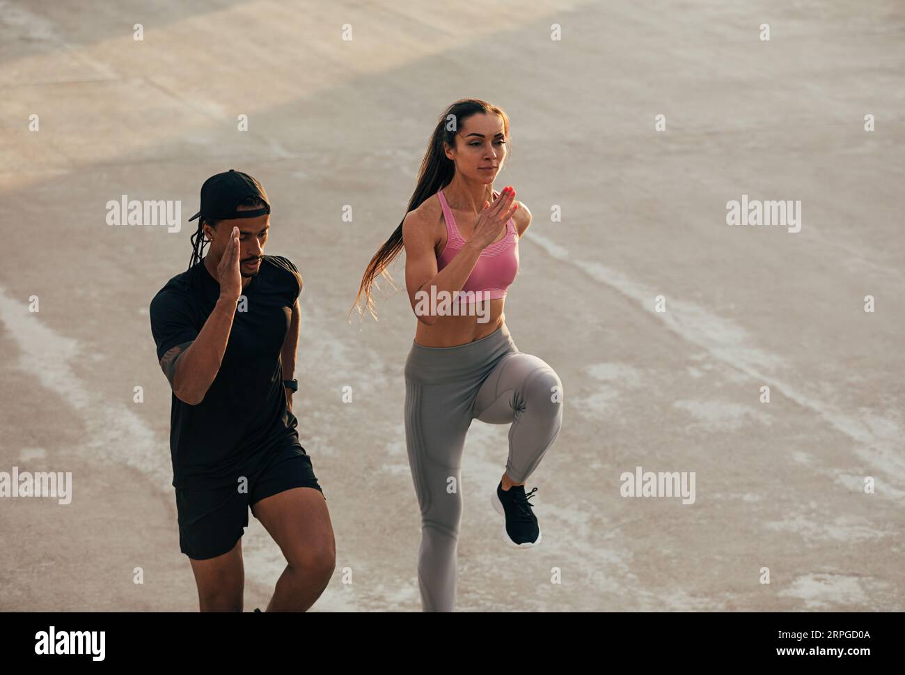 High angle of two athletes jumping together doing warming up before a ...