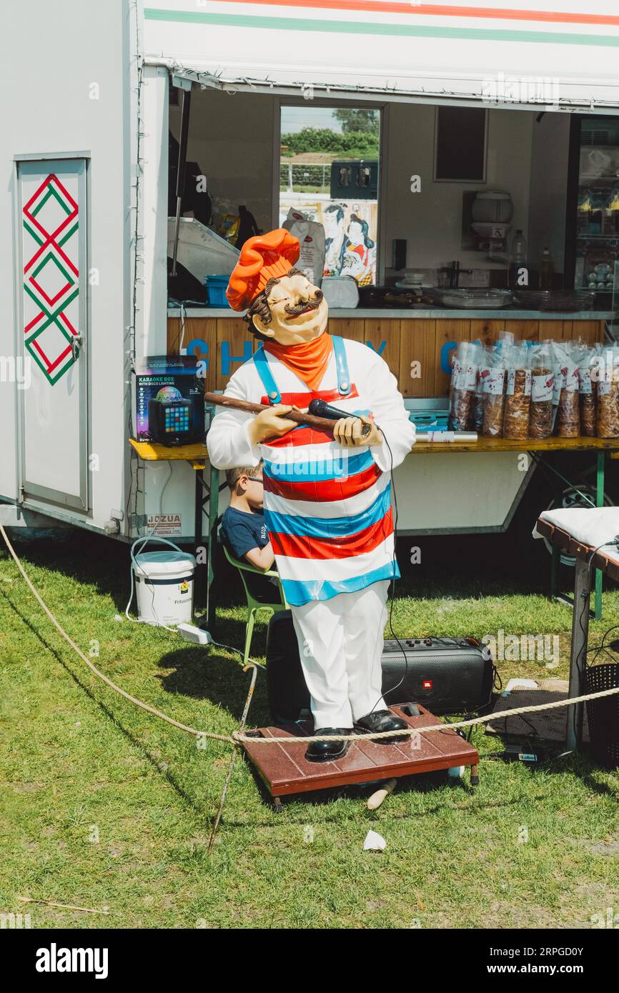 A funny cute colorful statue of an italian cook standing in front of a ...