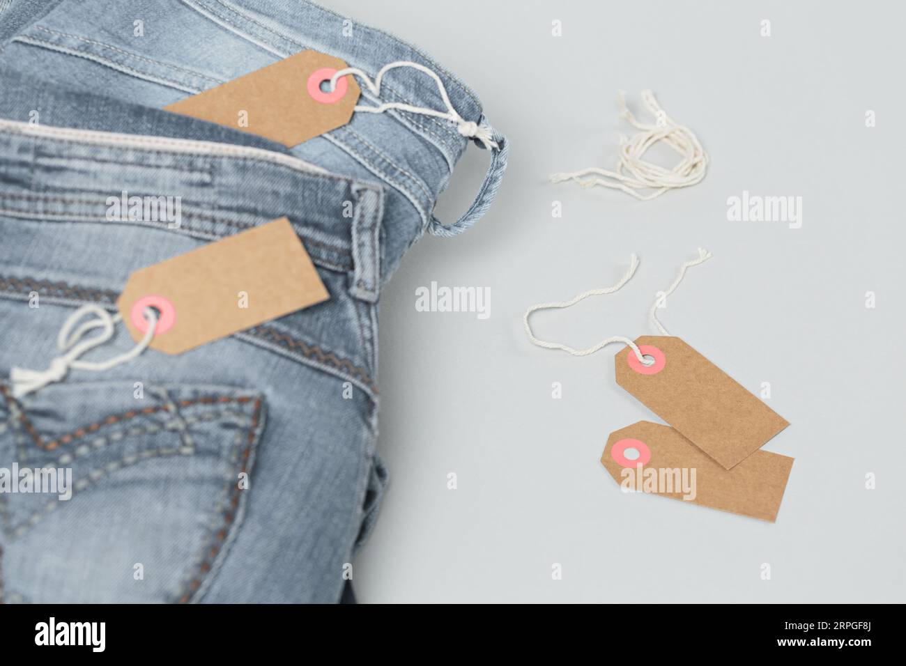 Stack of blue jeans and empty tags on white background Stock Photo - Alamy