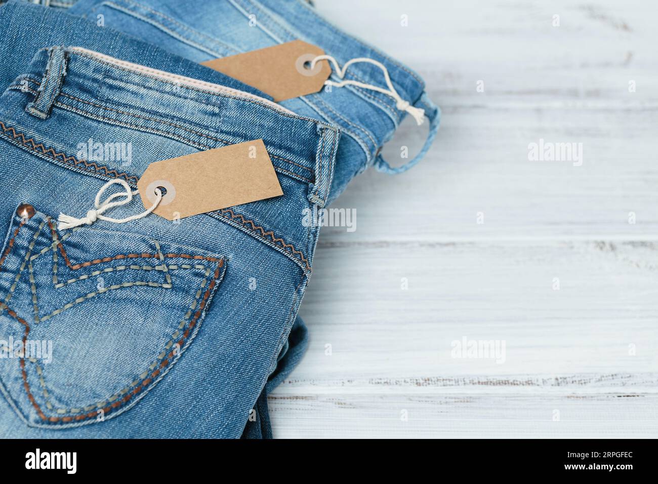 Stack of blue jeans and empty tags on white background Stock Photo - Alamy