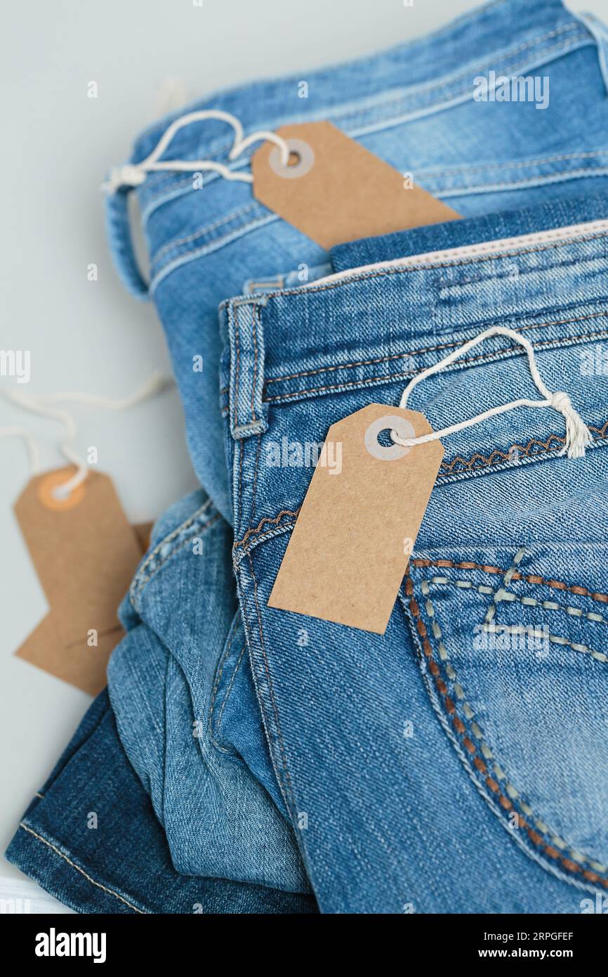 Stack of blue jeans and empty tags on white background Stock Photo - Alamy