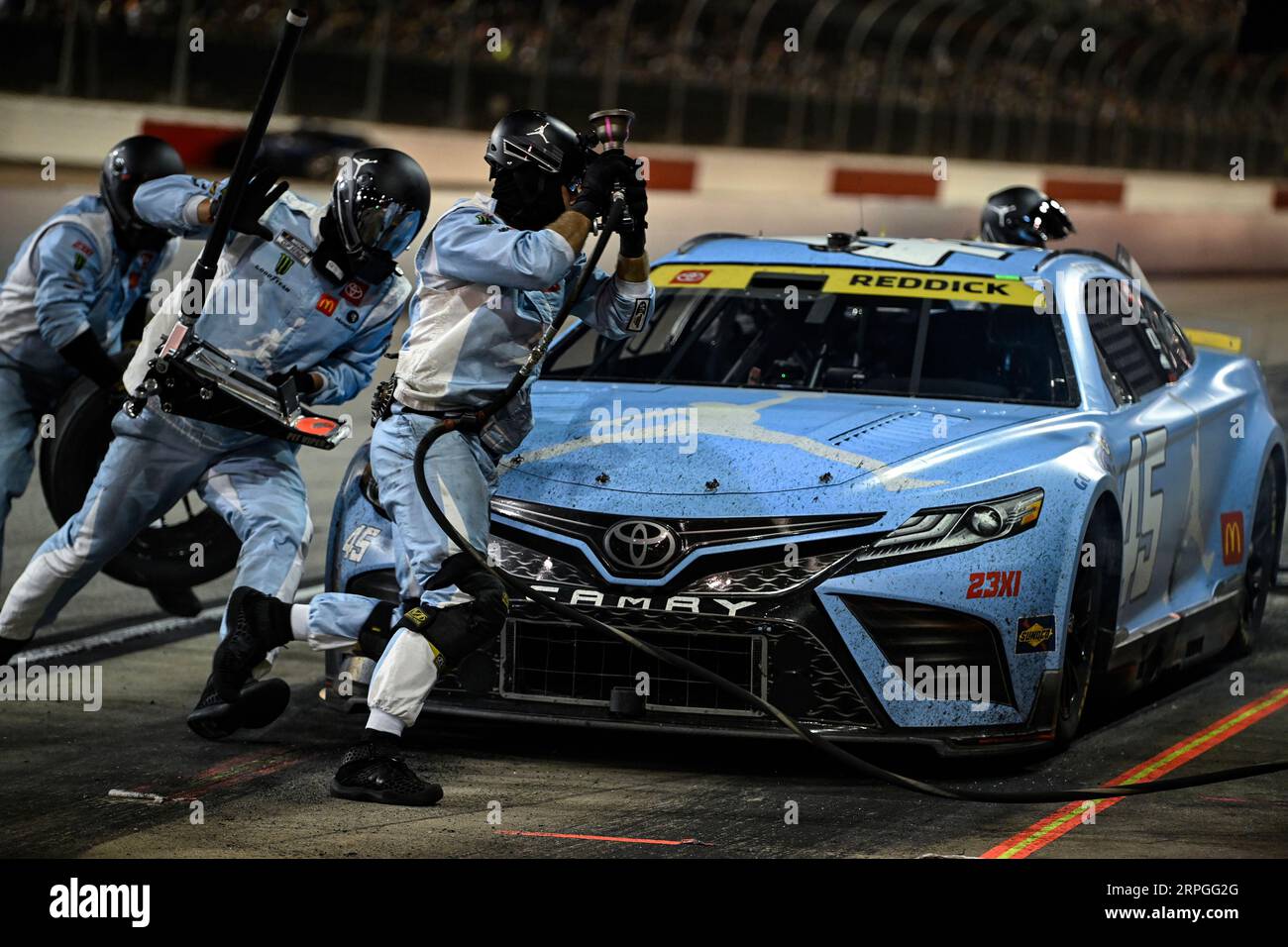 The pit crew for Tyler Reddick (45) rushes to complete a pit stop ...
