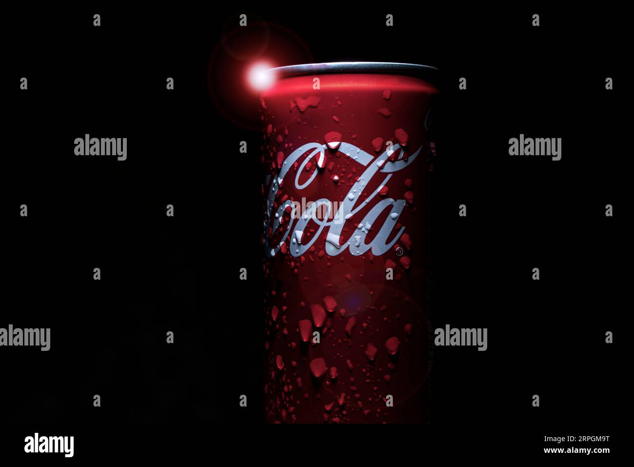 The Coca Cola drink on a black background, lens flare effected, macro ...