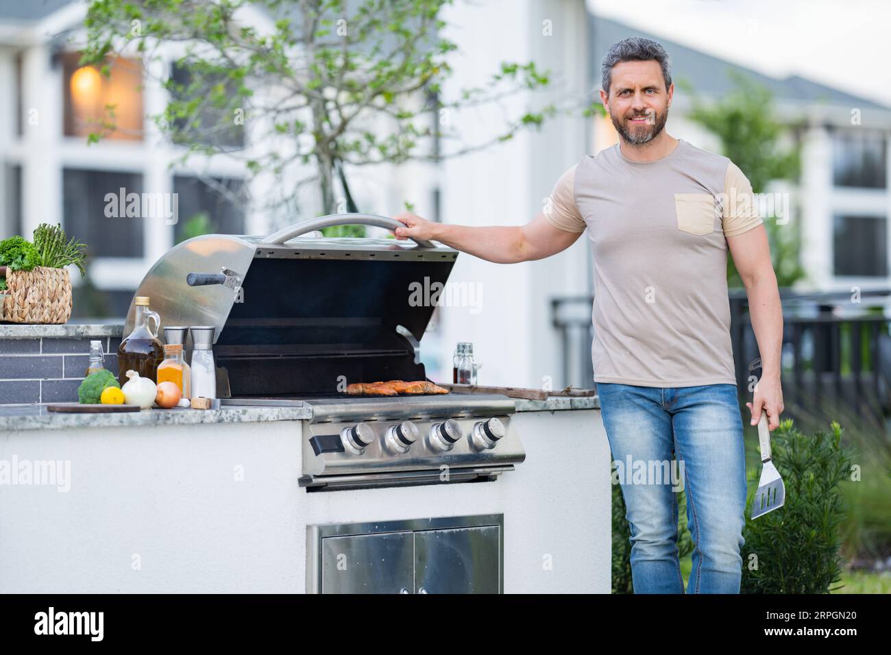 Man at barbecue grill. Male cook preparing barbecue outdoors. Bbq meat ...