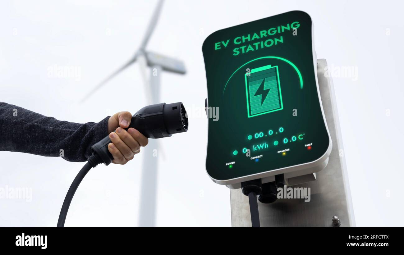 EV charger from EV car charging station in nature and wind turbine farm ...