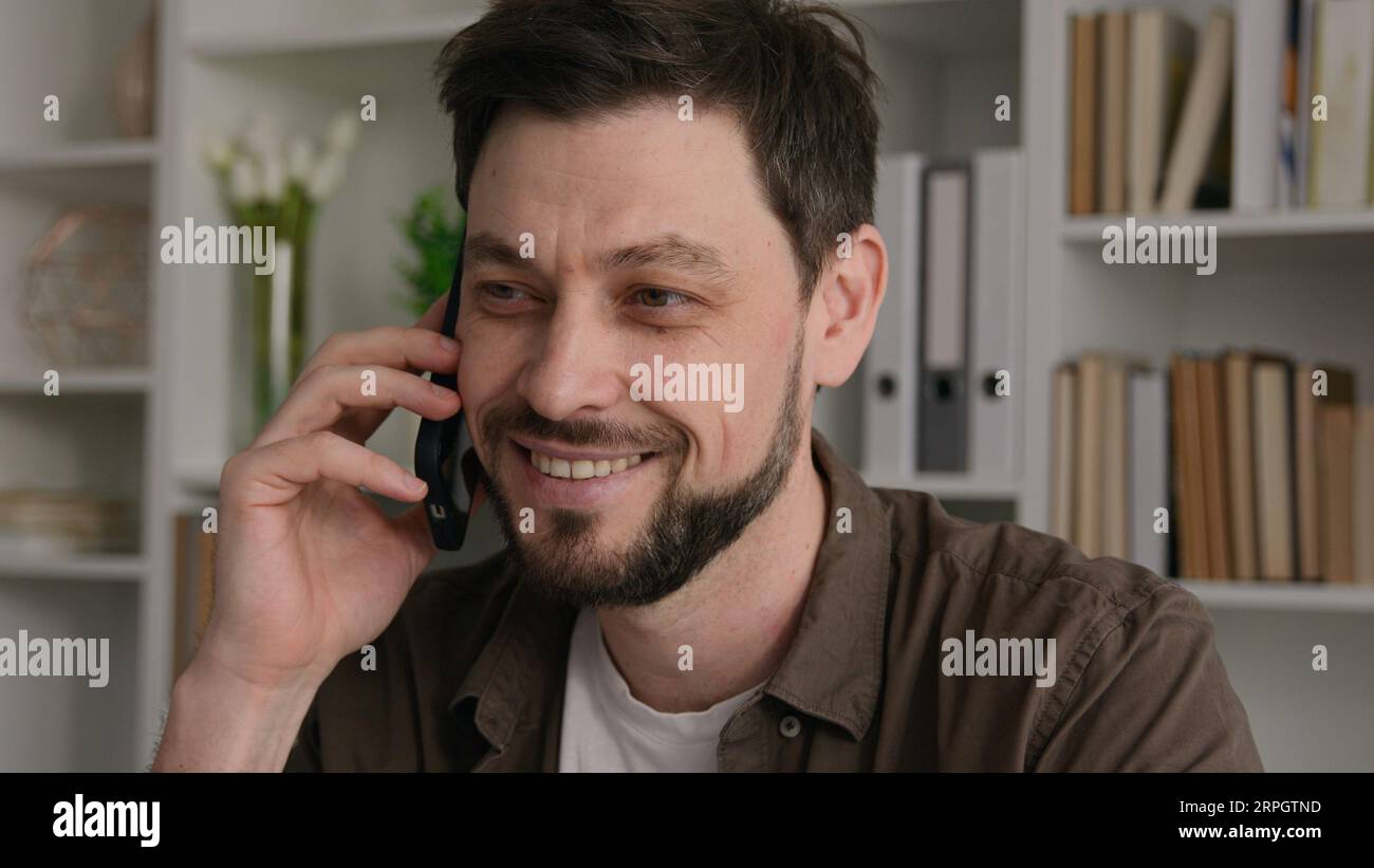 Caucasian smiling man male businessman executive manager graduate talk mobile phone at home ...