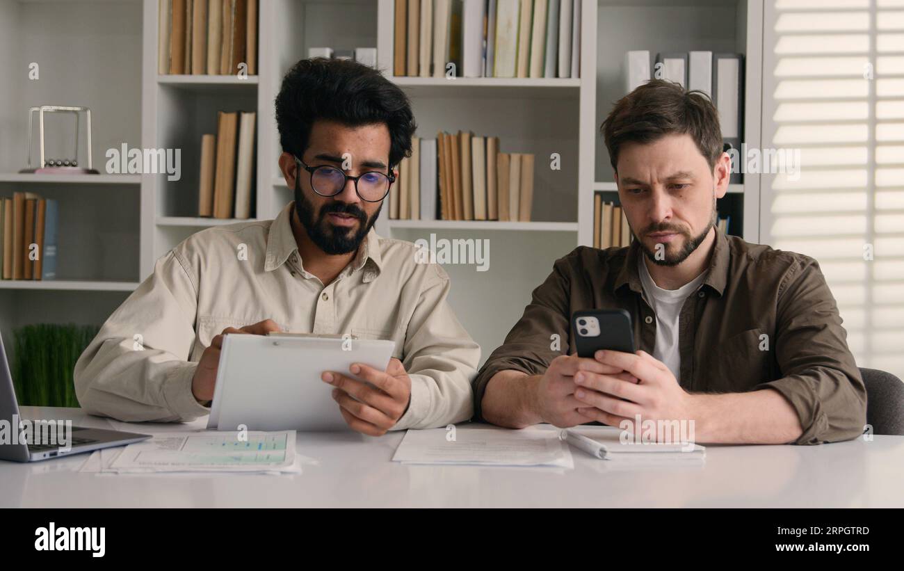 Two businessmen multiracial men co-workers in office Arabian Indian ...