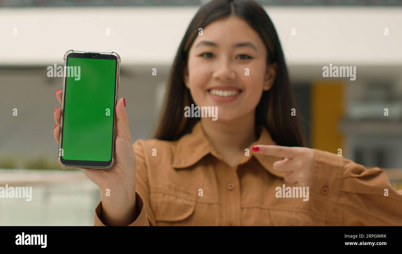 Asian chinese woman hold smartphone in front show mobile phone with ...