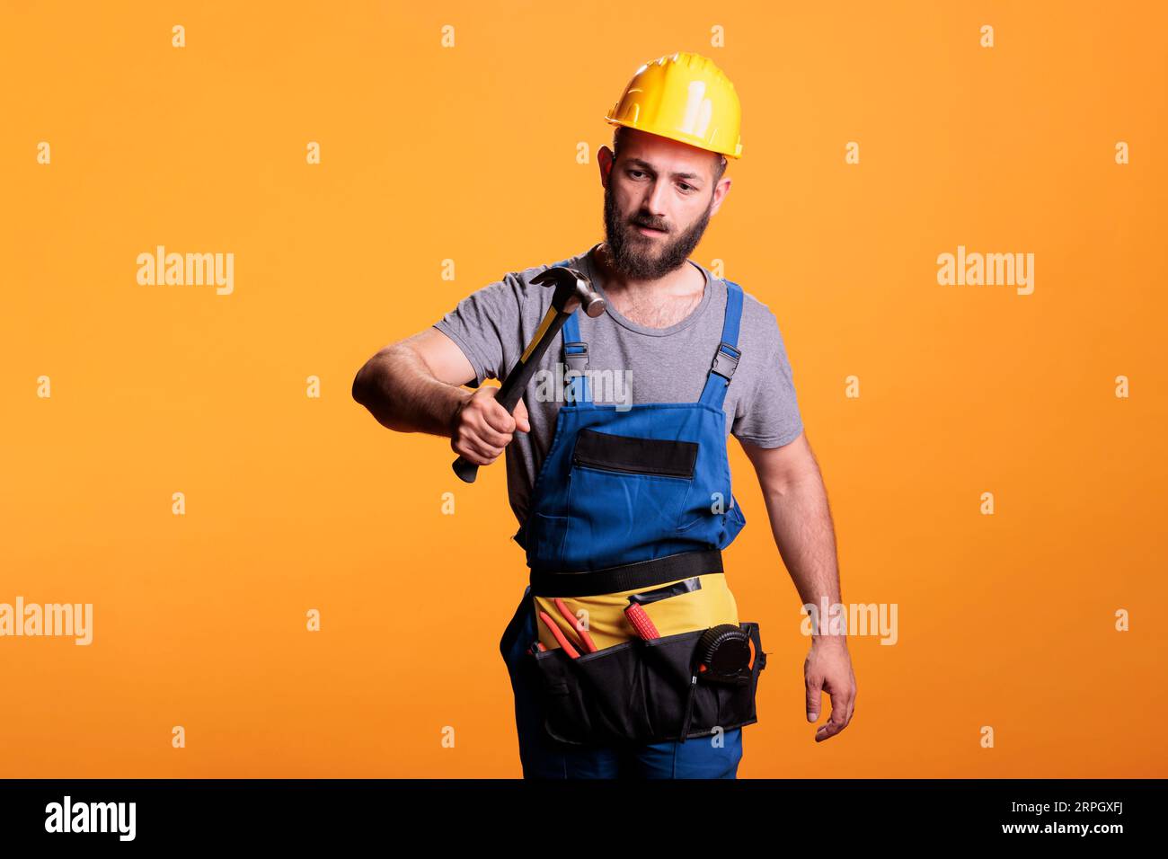 Construction worker using hammer on renovation project, standing over ...