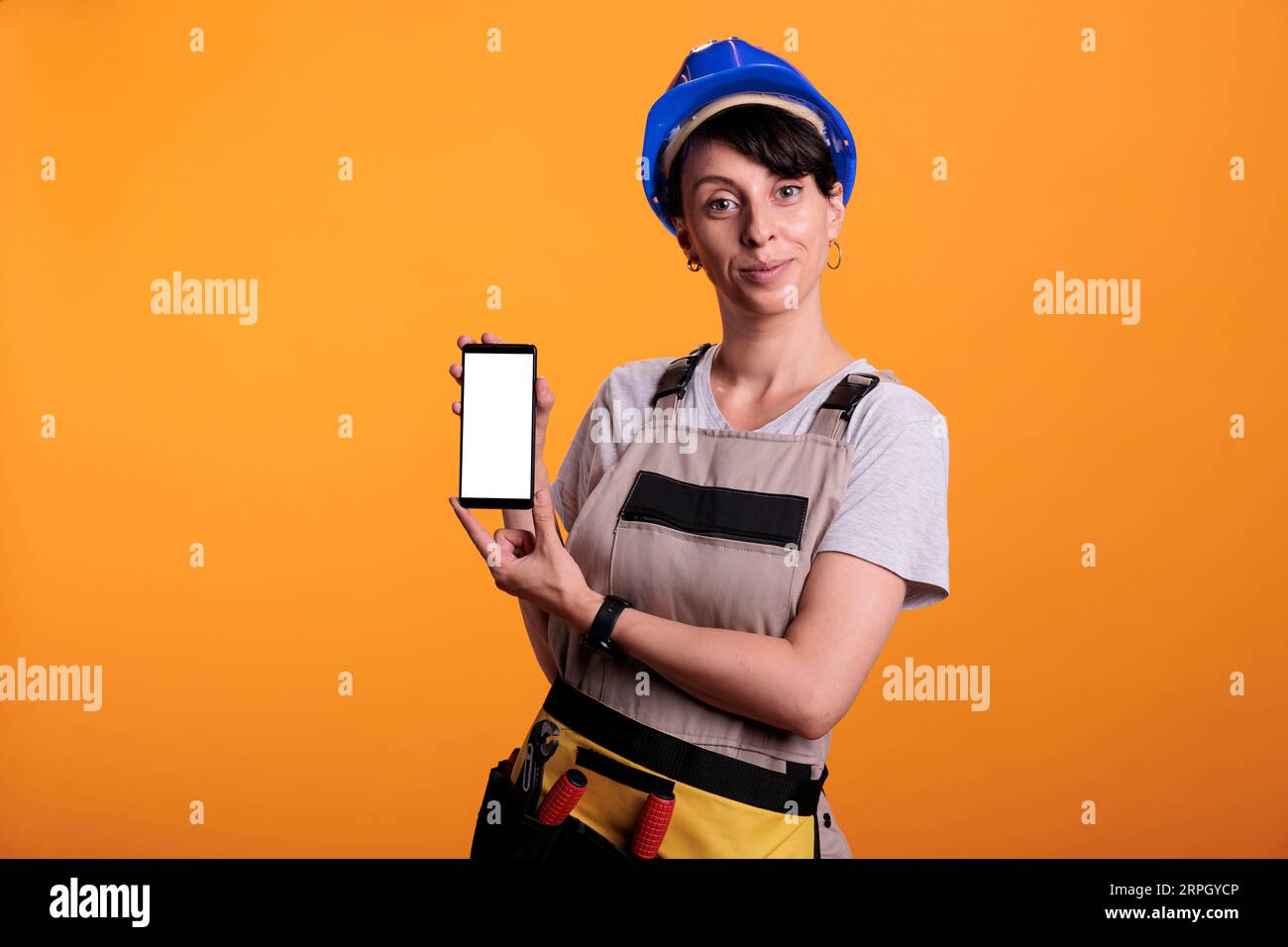 Female contractor showing blank white screen on mobile phone display ...