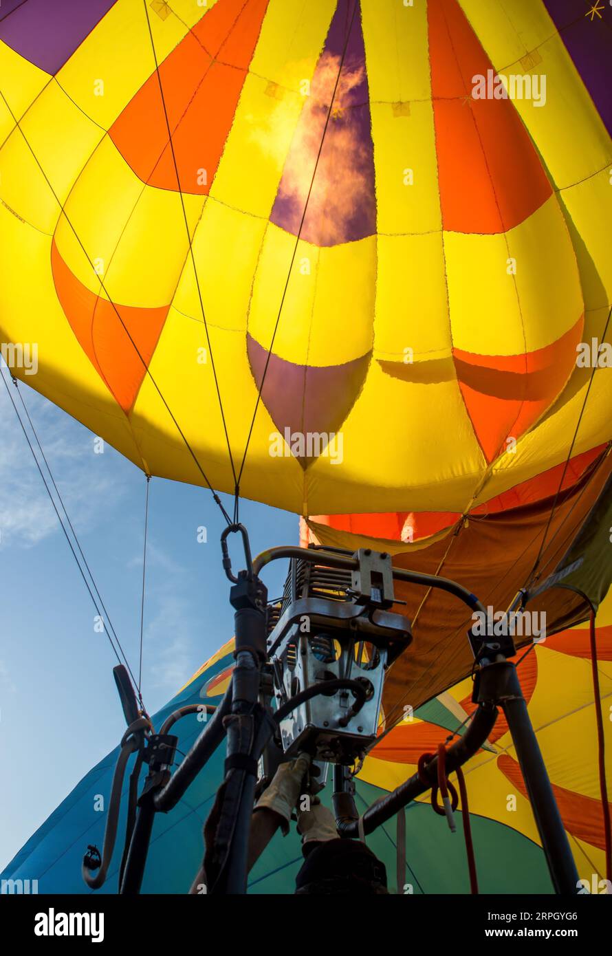 A bright flame from a propane gas engine is shooting into a hot air ...
