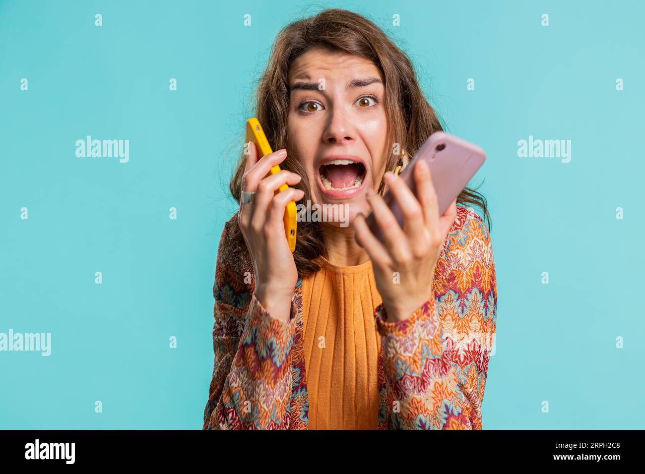Irritated nervous stressed young woman talking screaming on two mobile ...