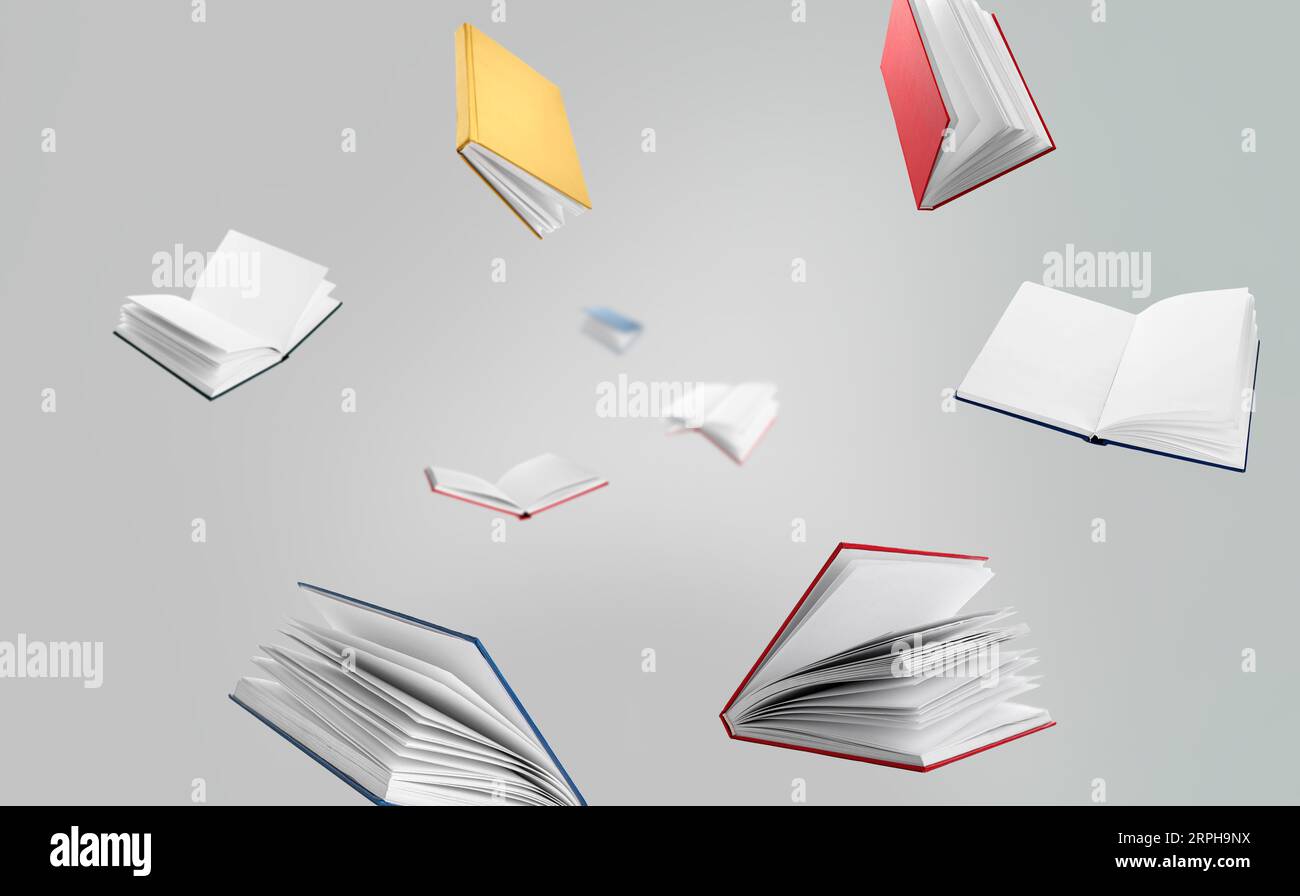 Many flying books on grey background Stock Photo - Alamy